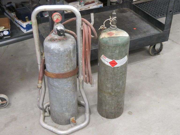 Two older Acetylene tanks, one gauge, small torch, and a wrench ...