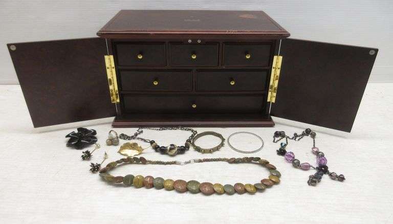 Six-drawer jewelry box with doors filled with rings, earrings ...