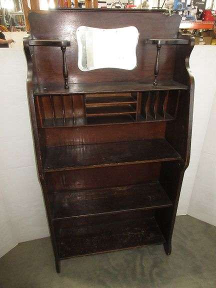 Antique bookcase with some slots, shelves for books, and mirror at top ...