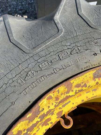 John Deere 14.9x24 rims and tires, the tires are weather checked, the ...