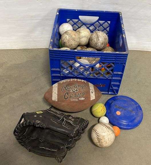 Milk crate full of softballs, hard balls, golf balls, footballs, and a ...