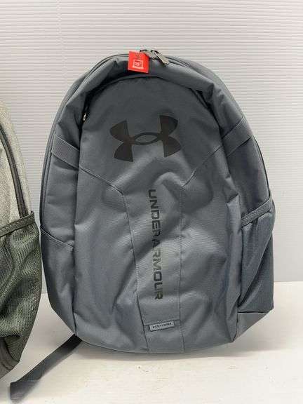 (2) Gray Under Armour backpacks, up to 21"H, new - Albrecht Auction Service