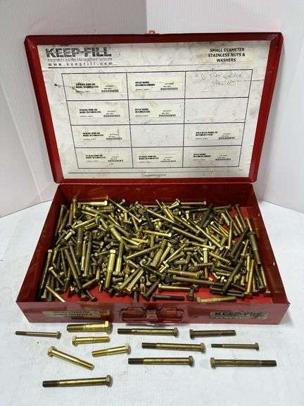 Red metal case filled with brass-tone bolts and very small washers ...