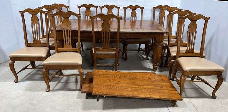 Solid oak table with two drawers, (2) leaves, and (12) chairs, table ...