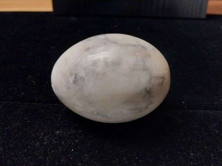 Smooth White Stone Shaped Like an Egg with Visible Marble Veins and ...