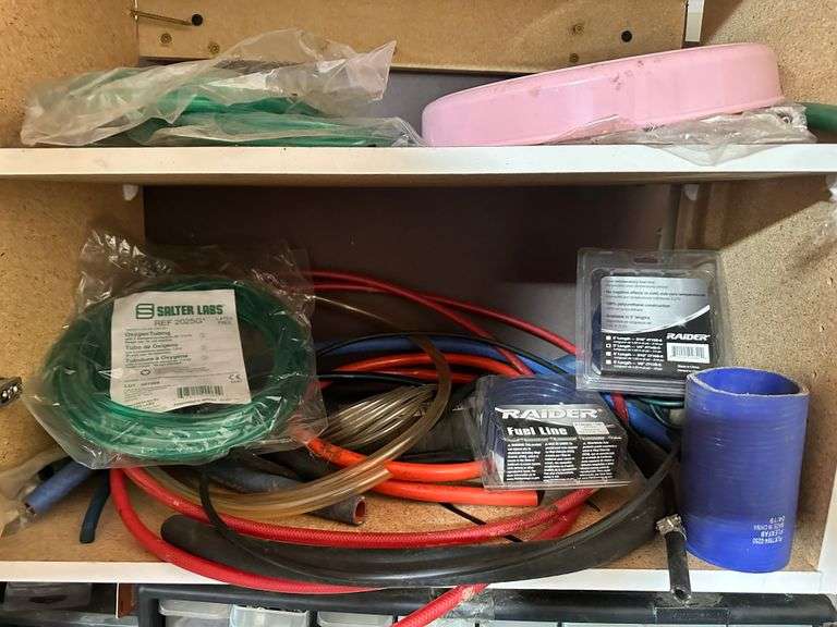 Shelf of fuel lines, oxygen tubing, and assorted rubber hose - Auction Ohio