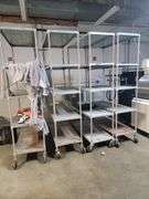 Four rolling metal shelving units approximately 8 ft tall and contents ...