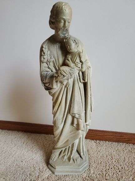 Concrete statue of St Joseph holding baby Jesus. Statue stands ...