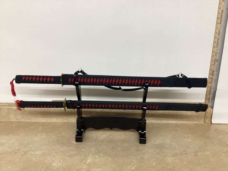2 RED AND BLACK SHEATH SWORDS ON STAND - Currie Auction Service
