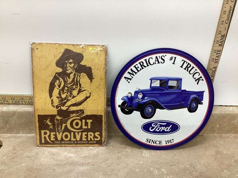 ROUND METAL FORD TRUCK SIGN AND COLT REVOLVER SIGN - Currie Auction Service