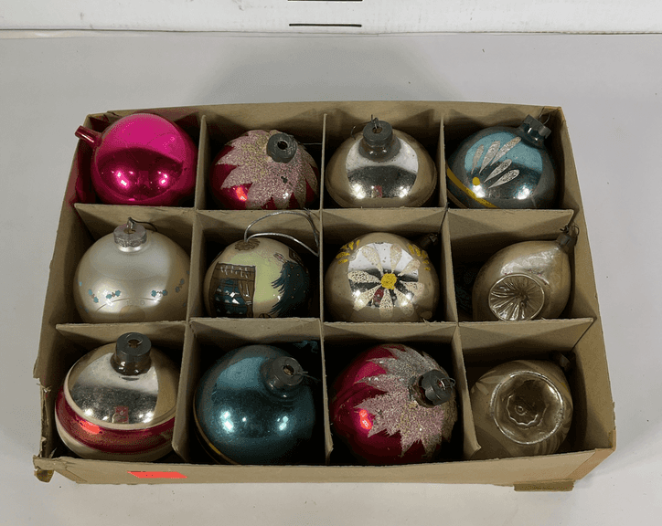 Eleven glass ornaments and one other. One glass ornament is broken as ...