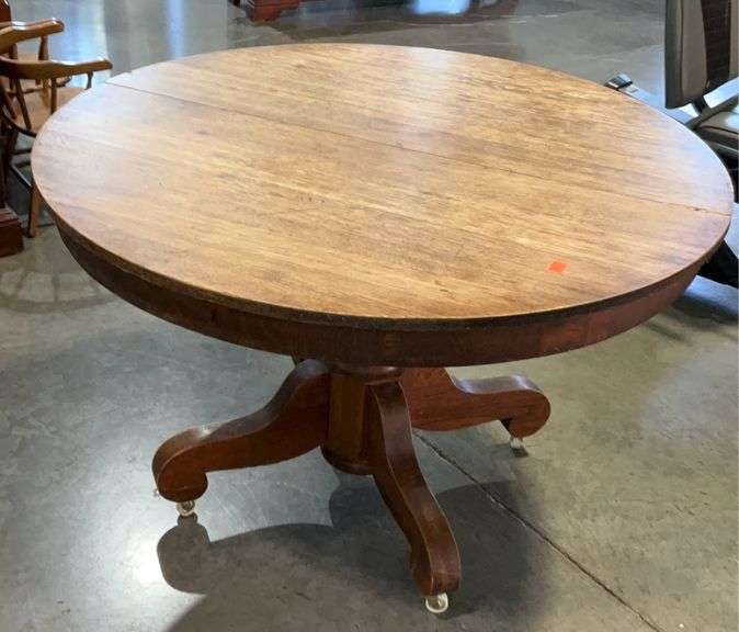 Round wood table on casters. No leaf 4’. Condition as shown - Hash Auctions
