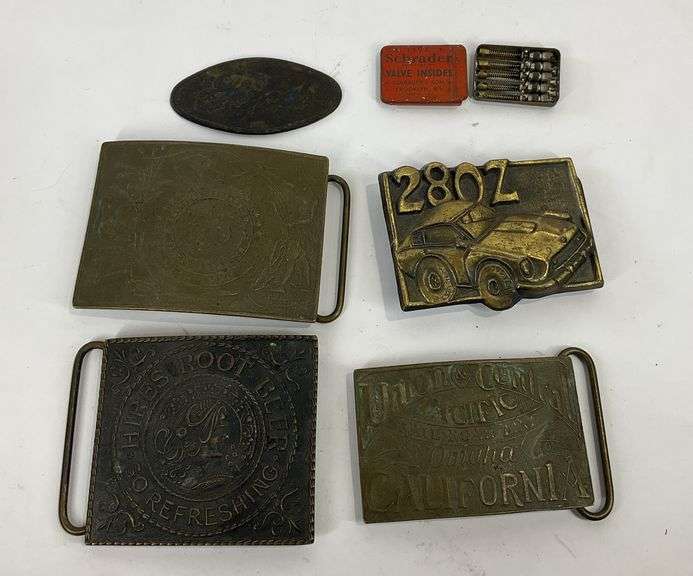 Four belt buckles, Schrader Valves, and a Ford Emblem - Hash Auctions
