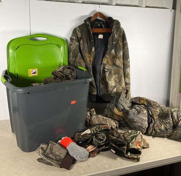 Large gray and green tote filled with hunting gear. Jackets, gloves and ...