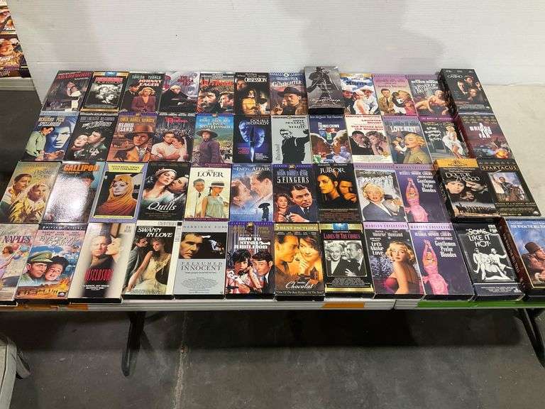VHS Tapes in Two Boxes Featuring Various Films - Hash Auctions