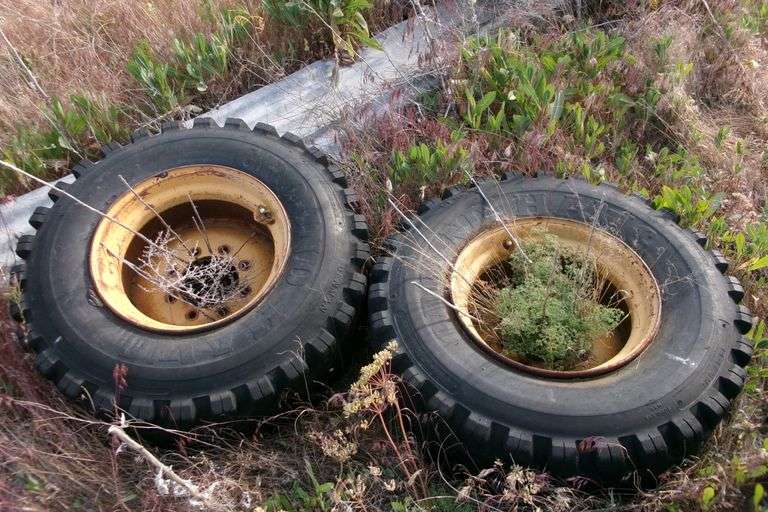 2 CASE BACKHOE WHEELS, misc pallets of CANNED GREASE, TRAILER RIM ...