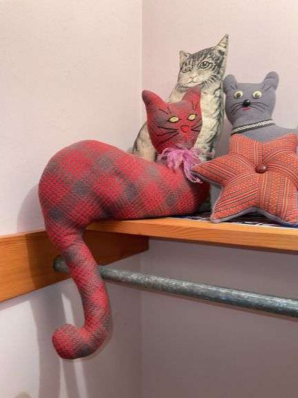 Contents of shelf: stuffed cloth cats and others, cat figurines ...