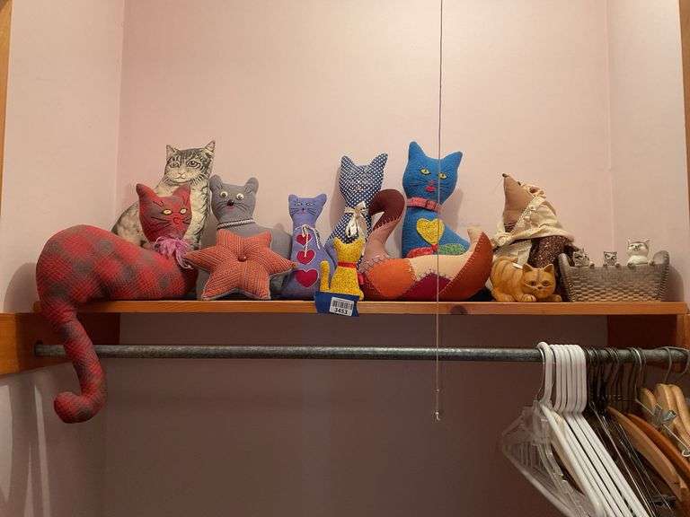 Contents of shelf: stuffed cloth cats and others, cat figurines ...
