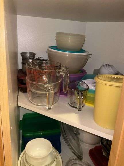 Contents of cupboard: Pyrex, measuring cups, Tupperware, plasticware ...
