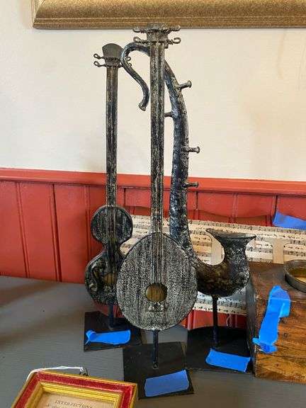 Three metal musical instrument sculptures, wooden votive holder block ...