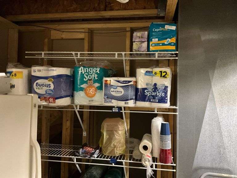 Contents of four shelves: bath tissue, paper towels, rolled rugs ...