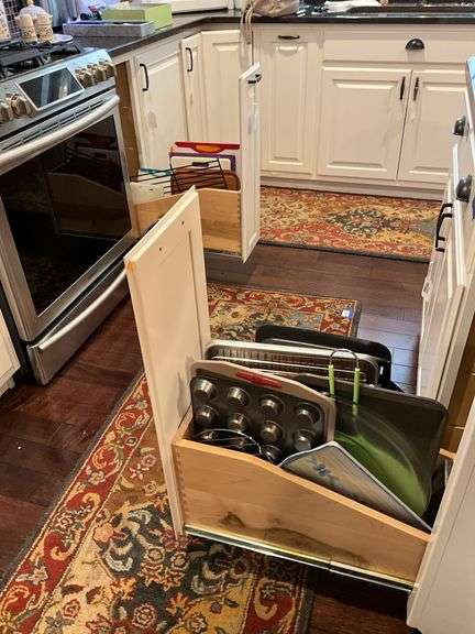 Contents of two pull-out cupboards: baking pans and trays, cutting ...