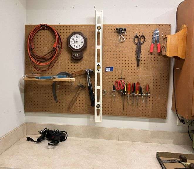 Electric drill and contents of pegboard: wall clock, extension cord ...