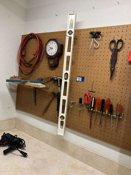 Electric drill and contents of pegboard: wall clock, extension cord ...
