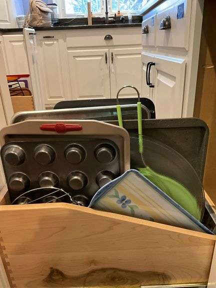 Contents of two pull-out cupboards: baking pans and trays, cutting ...