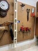 Electric drill and contents of pegboard: wall clock, extension cord ...