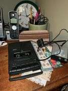 Contents of desk top and underneath: cordless phones, digital camera ...