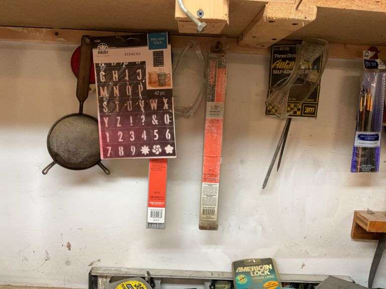 Misc tools, hardware, fan, and items hanging on wall above - Hurley Real Estate & Auctions
