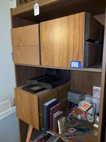 Contents of two shelves: tape storage units, adding machine tape, wire ...