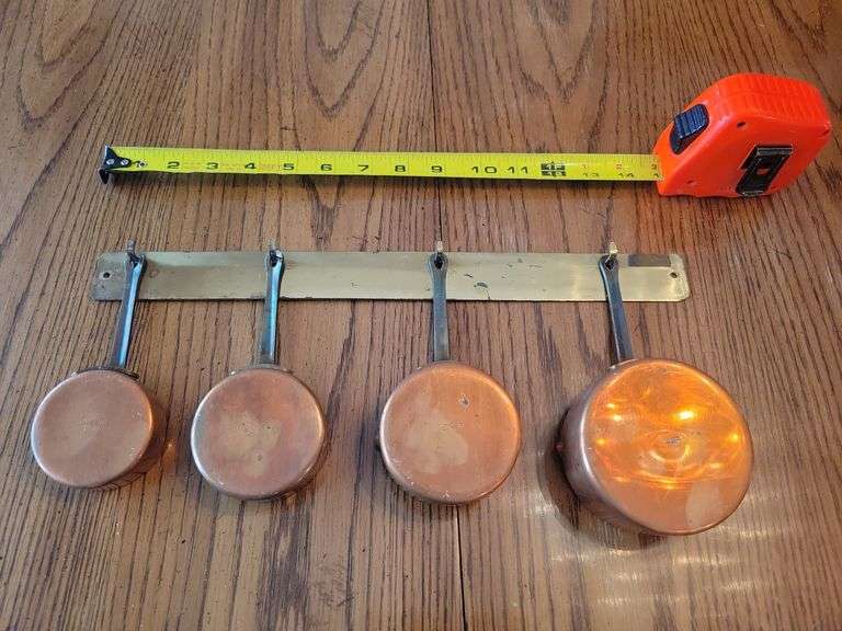 SET OF (4) COPPER FINISH MEASURING CUPS ON WALL MOUNTED HANGER ...