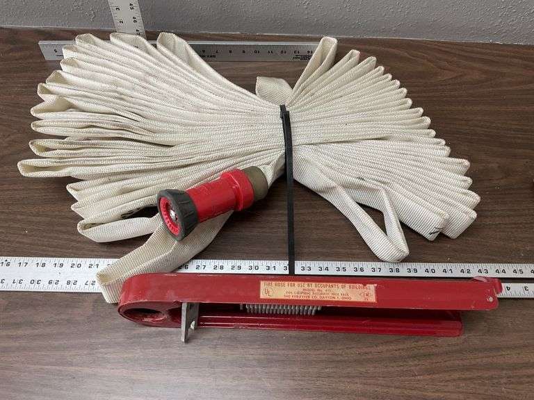 Fire hose bracket with hose and nozzle - Legacy Auction Company