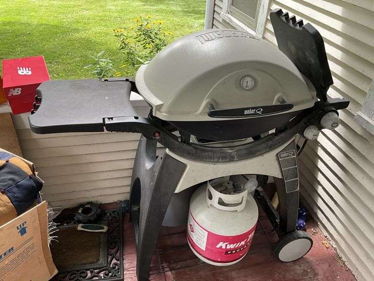 Weber gas grill with tank, mostly full - Legacy Auction Company