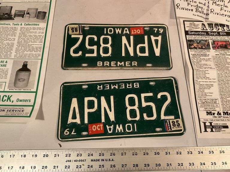 Trash can with sale bills, unique license plates - Legacy Auction Company