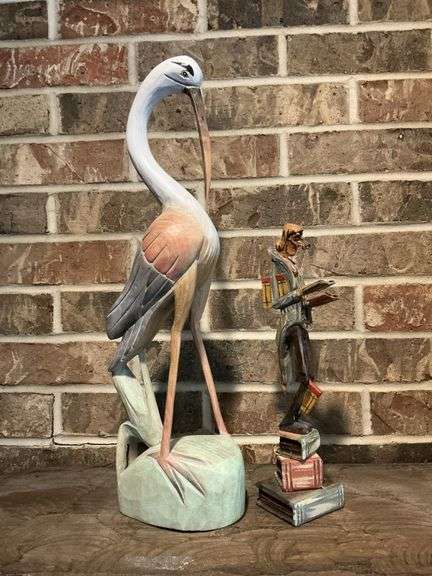 Carved bird & man on books - Legacy Auction Company
