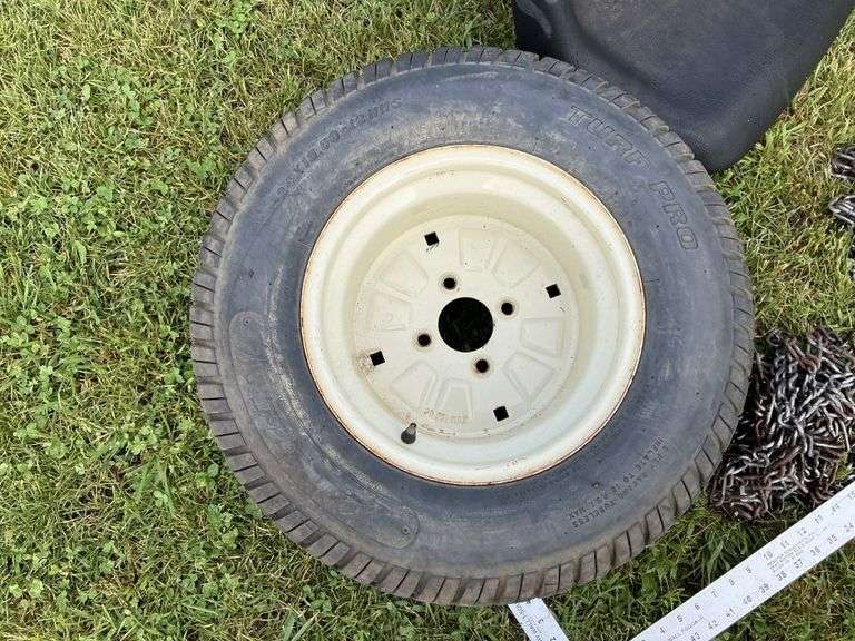 Mower tire rim, seat and chains - Legacy Auction Company