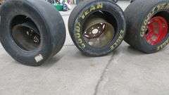 Three Goodyear Drag Slicks w/Rims 25.5x14.0-16 - Lambrecht Auction, Inc.
