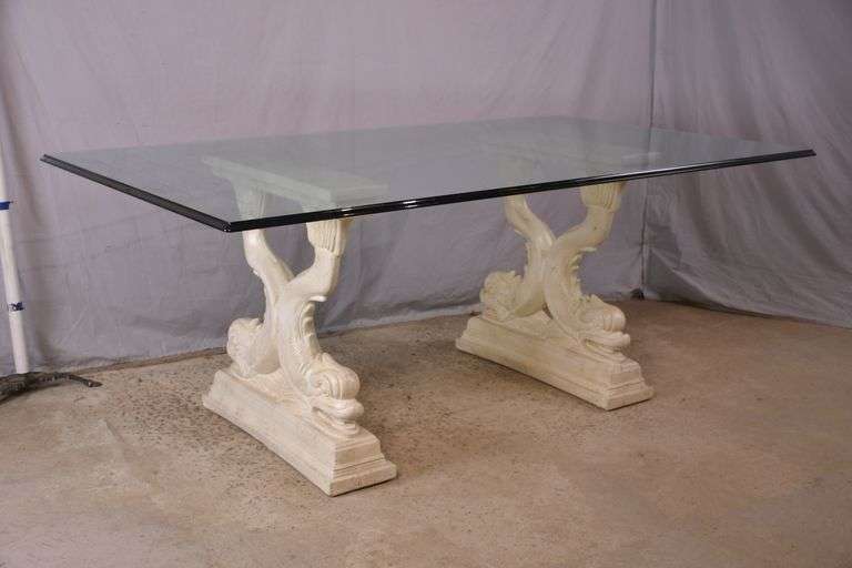 Large glass top dining table with off-white plaster dolphin pedestals ...