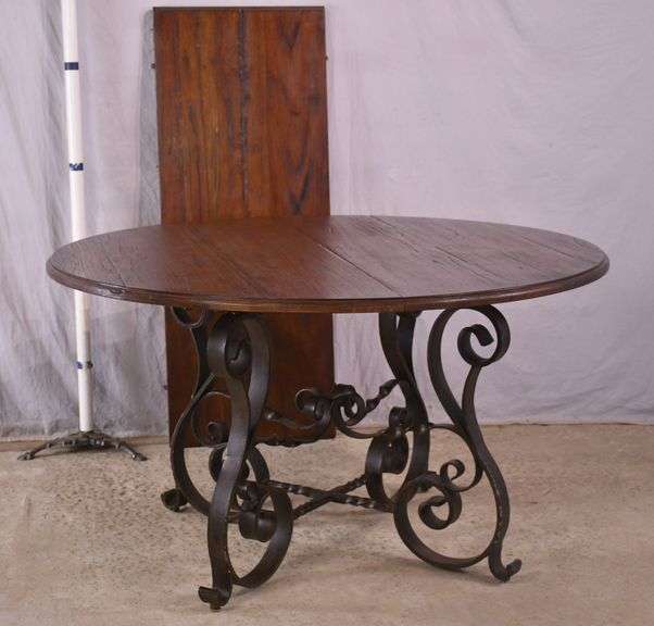 Round distressed top dining table with ornate iron base and 1 leaf; 68 ...
