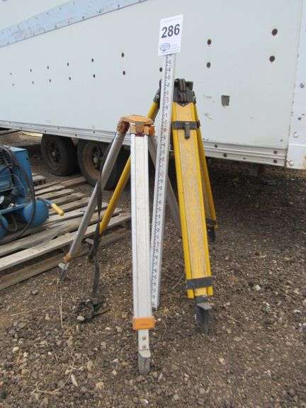 2 TRANSIT TRIPODS AND A MEASURING STICK - McPherson Auction & Realty