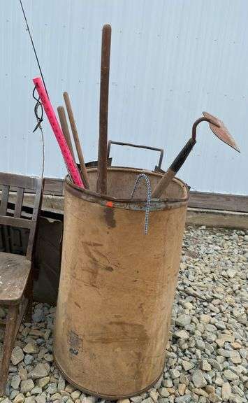 Cardboard barrel with tools assortment including rake, yoke part, yard ...