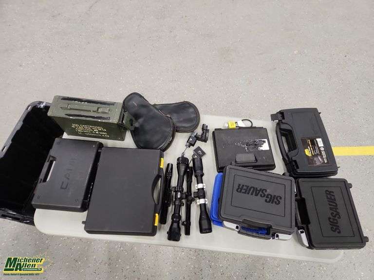 Open Bin Containing Various Gun Cases and Scopes and An Amo Case ...