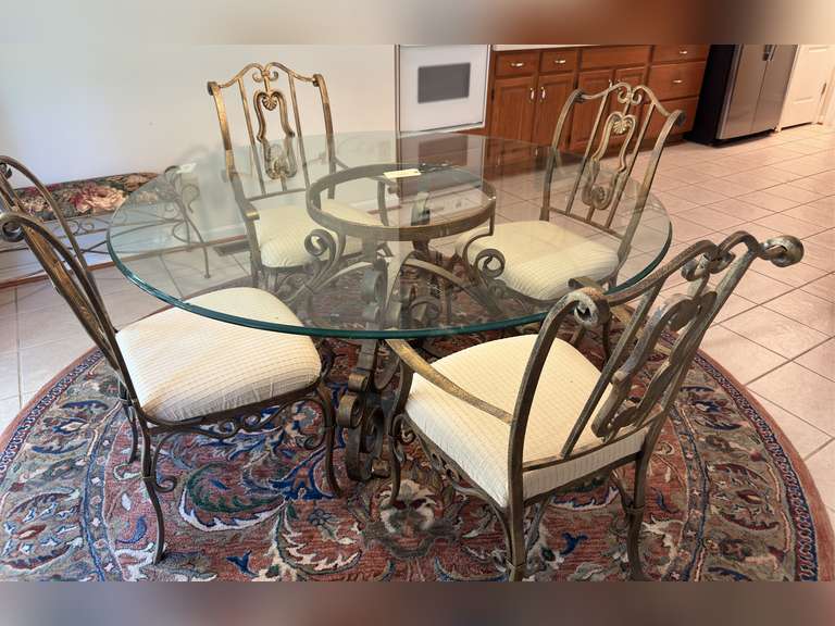 Wrought iron glass top round table with four chairs. Table is 57 inches ...