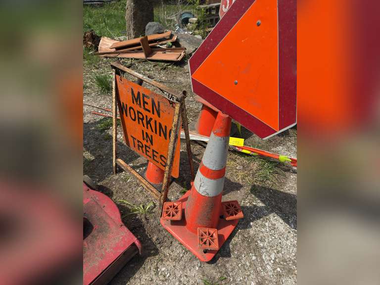 Two safety cones, "Men Working In Trees" sign in an A-frame and a farm ...