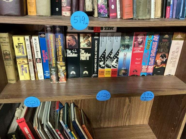 shelf of a few books and VHS tapes - SCHULTIS & SON, INC.