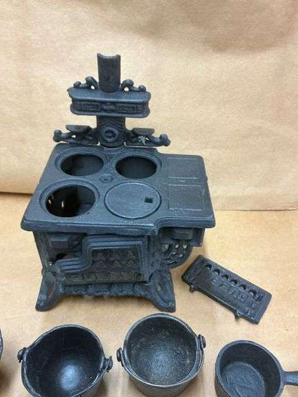 Miniature cast-iron wood-burning cook stove with pots, pans, and ash ...