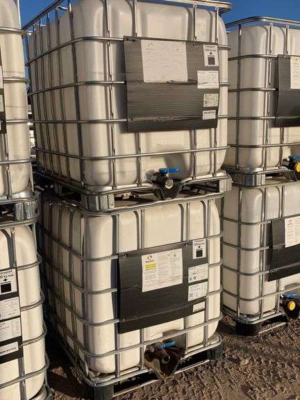 (2) 275 gallon liquid containers with protective metal cage and drain ...